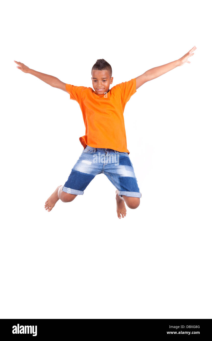 Portrait of a cute teenage black boy jumping over white background ...