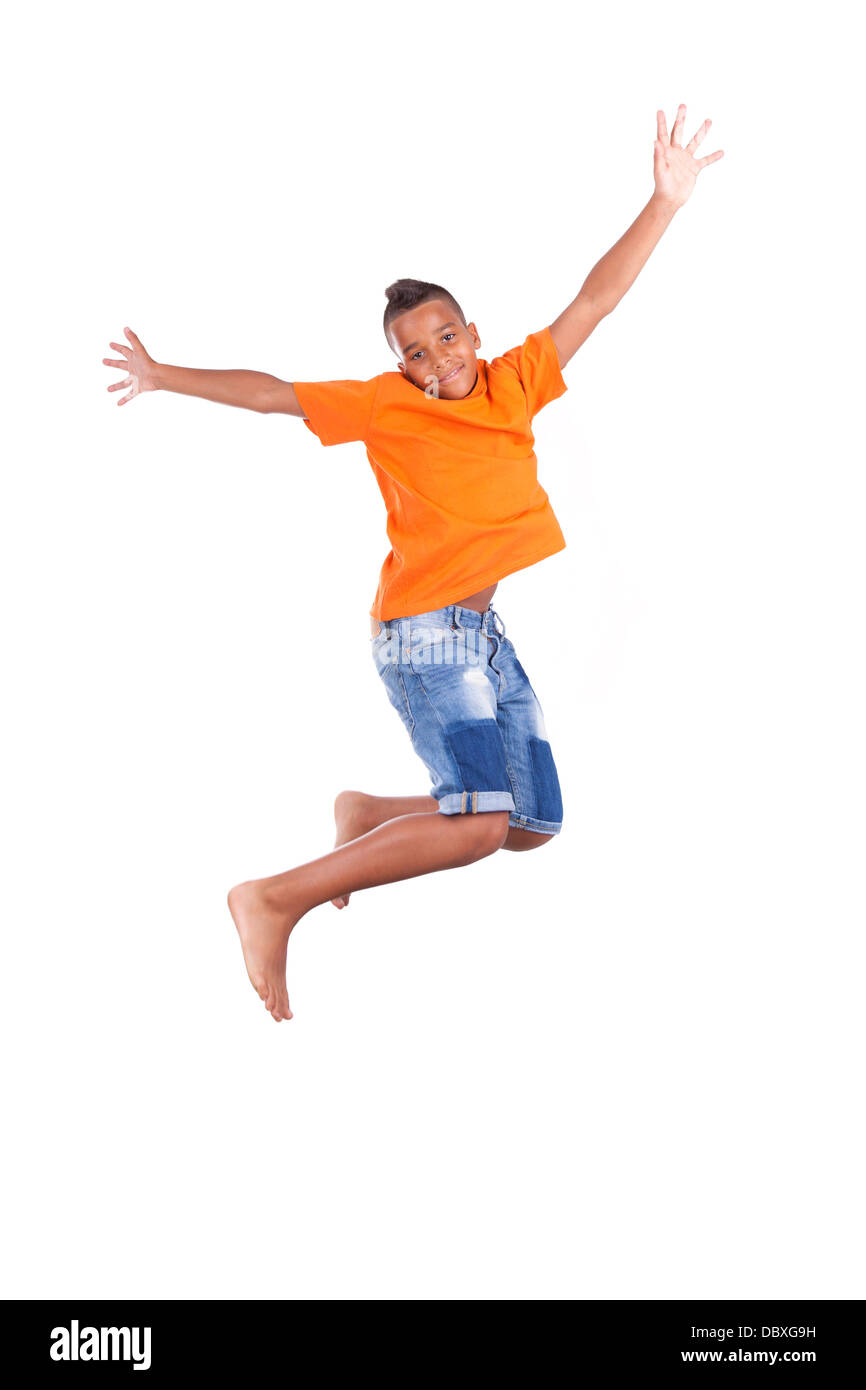 Portrait of a cute teenage black boy jumping over white background ...