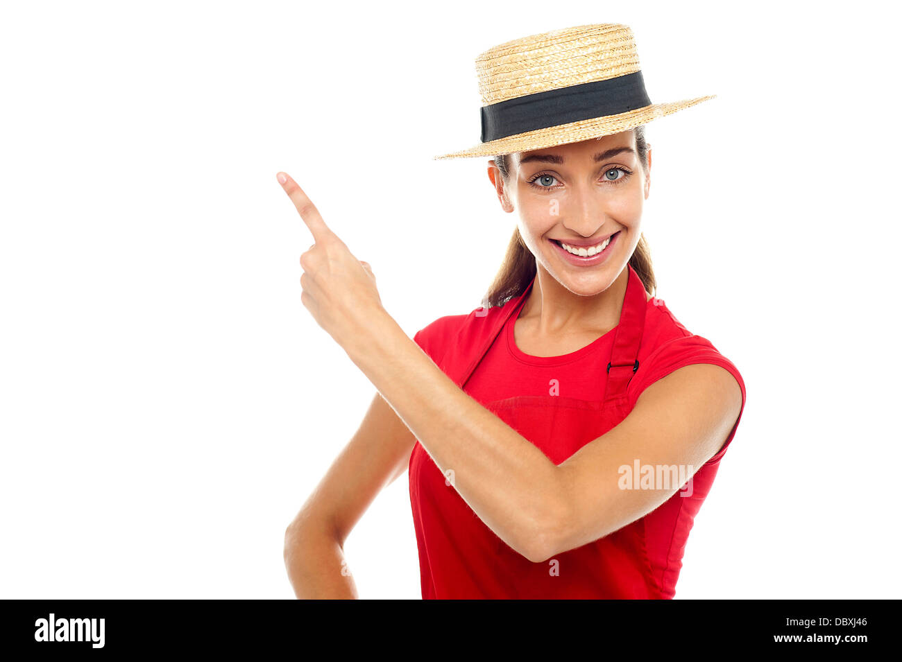 Smiling woman wearing straw bowler hat pointing away Stock Photo - Alamy