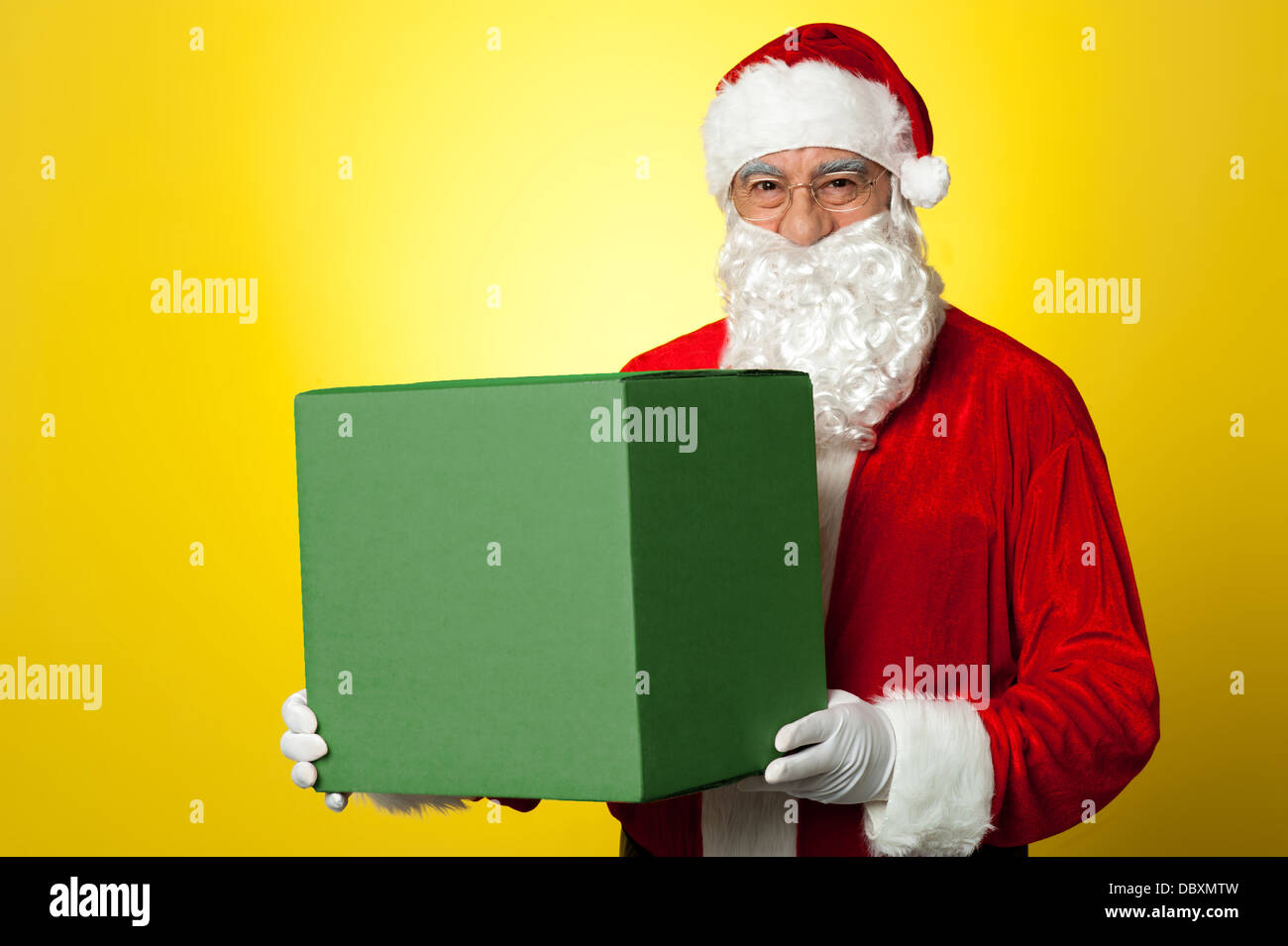 Santa Claus delivering big green gift box Stock Photo - Alamy