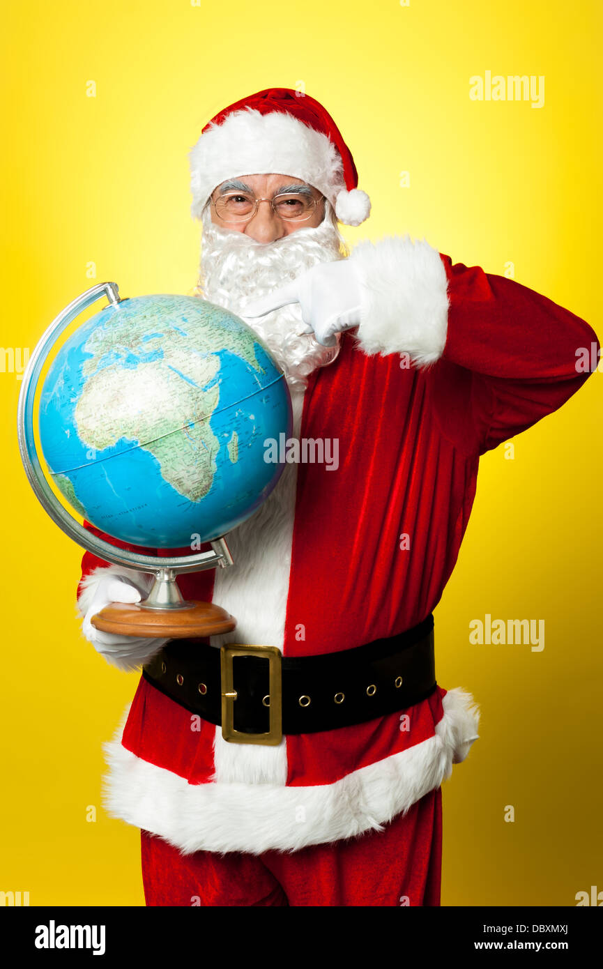 Father Christmas showing his country on globe Stock Photo - Alamy