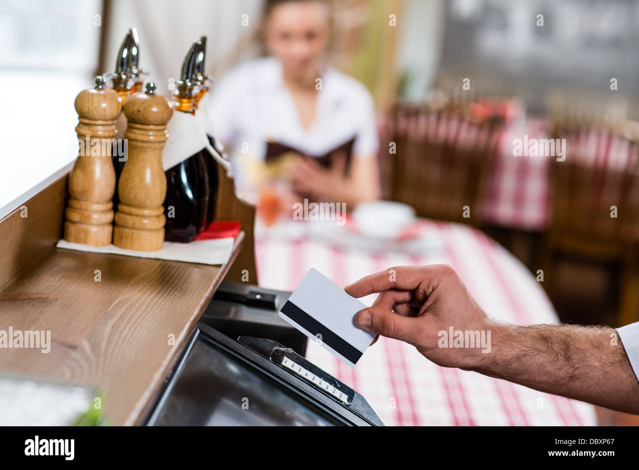waiter inserts the card into a computer terminal Stock Photo - Alamy