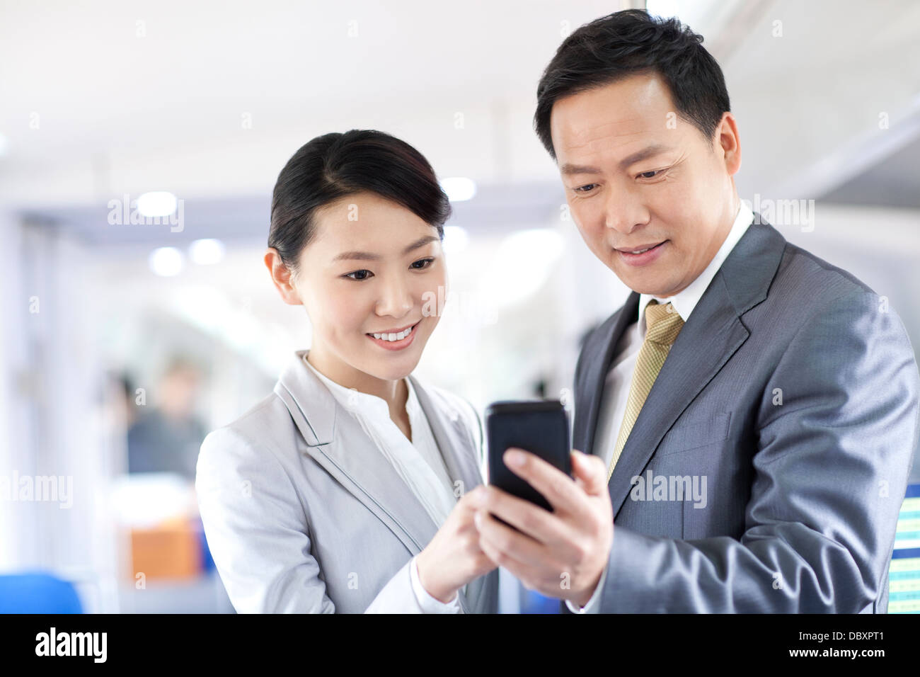 Business associates with smart phone in subway train Stock Photo - Alamy