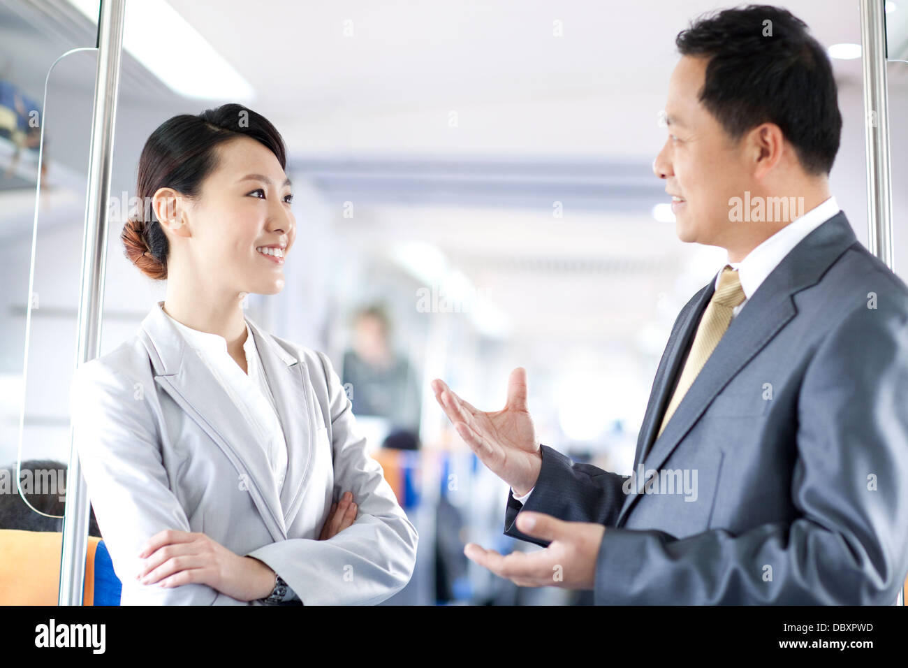 Business associates talking in subway train Stock Photo - Alamy