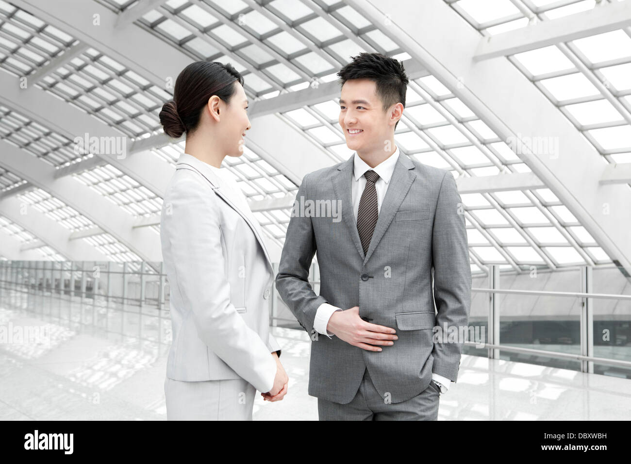 Business partners talking in airport lobby Stock Photo - Alamy