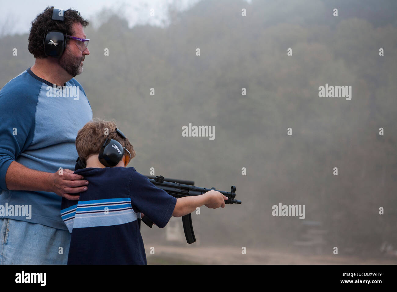 A father helping his young son fire a machine gun at the Knob Creek ...