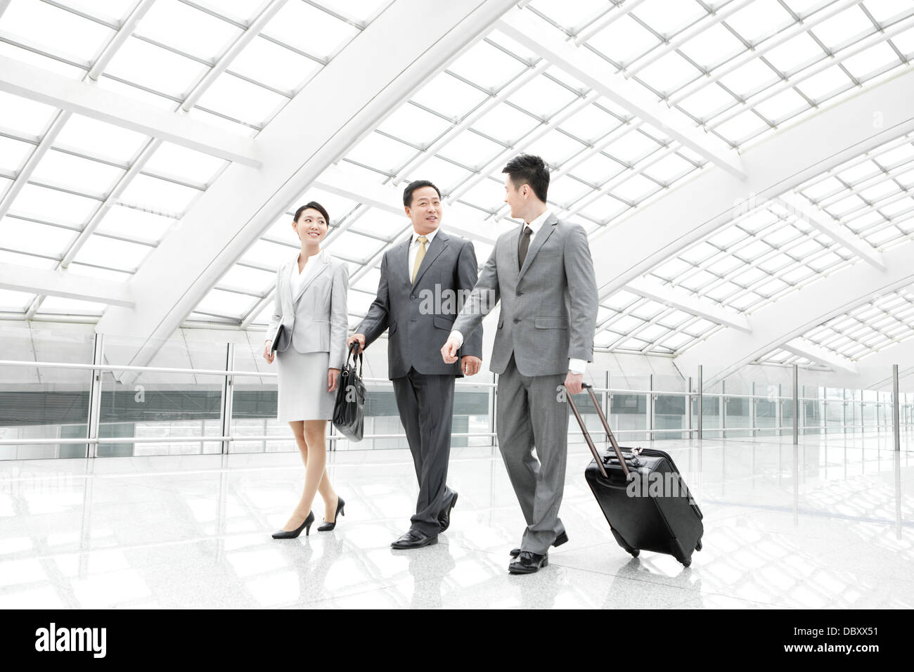 Business partners on the move in airport lobby Stock Photo - Alamy