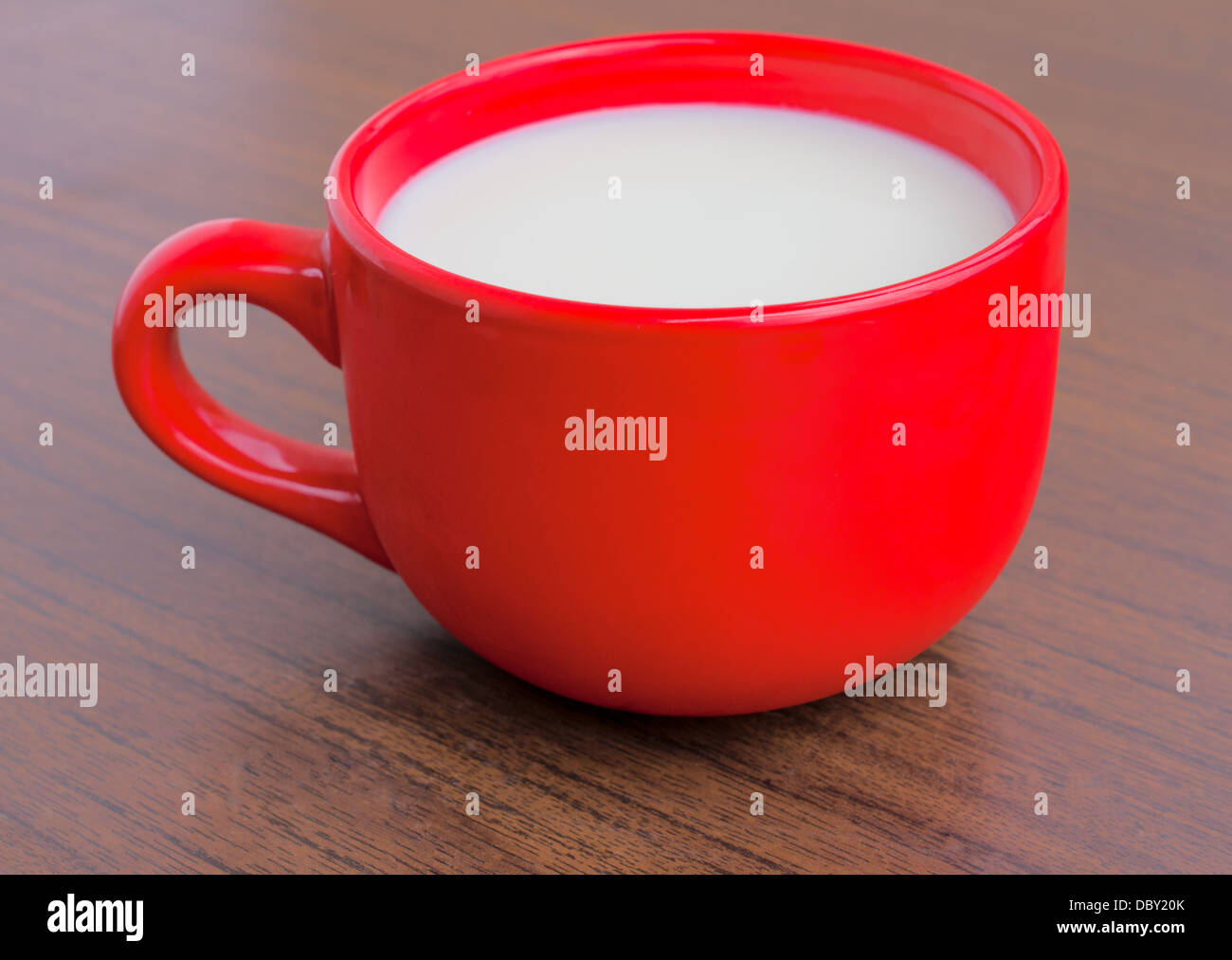 milk is poured into a red ceramic mug Stock Photo - Alamy