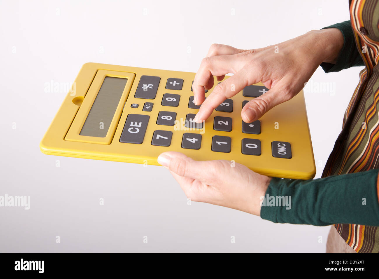 typing on big yellow calculator Stock Photo - Alamy