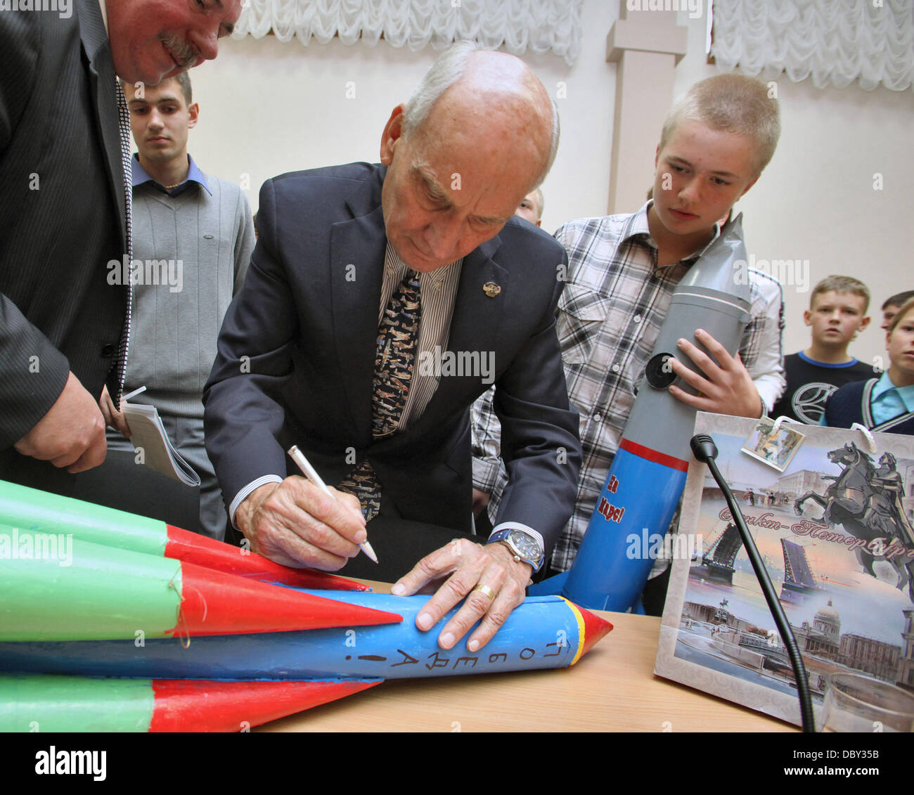 American astronaut Edwin Jacob Garn signs a model rocket during a visit ...