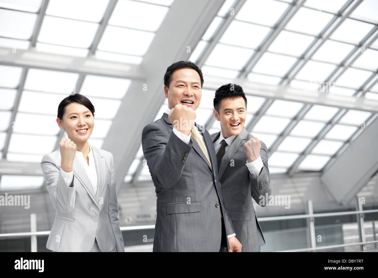Excited business people celebrating in airport lobby Stock Photo - Alamy