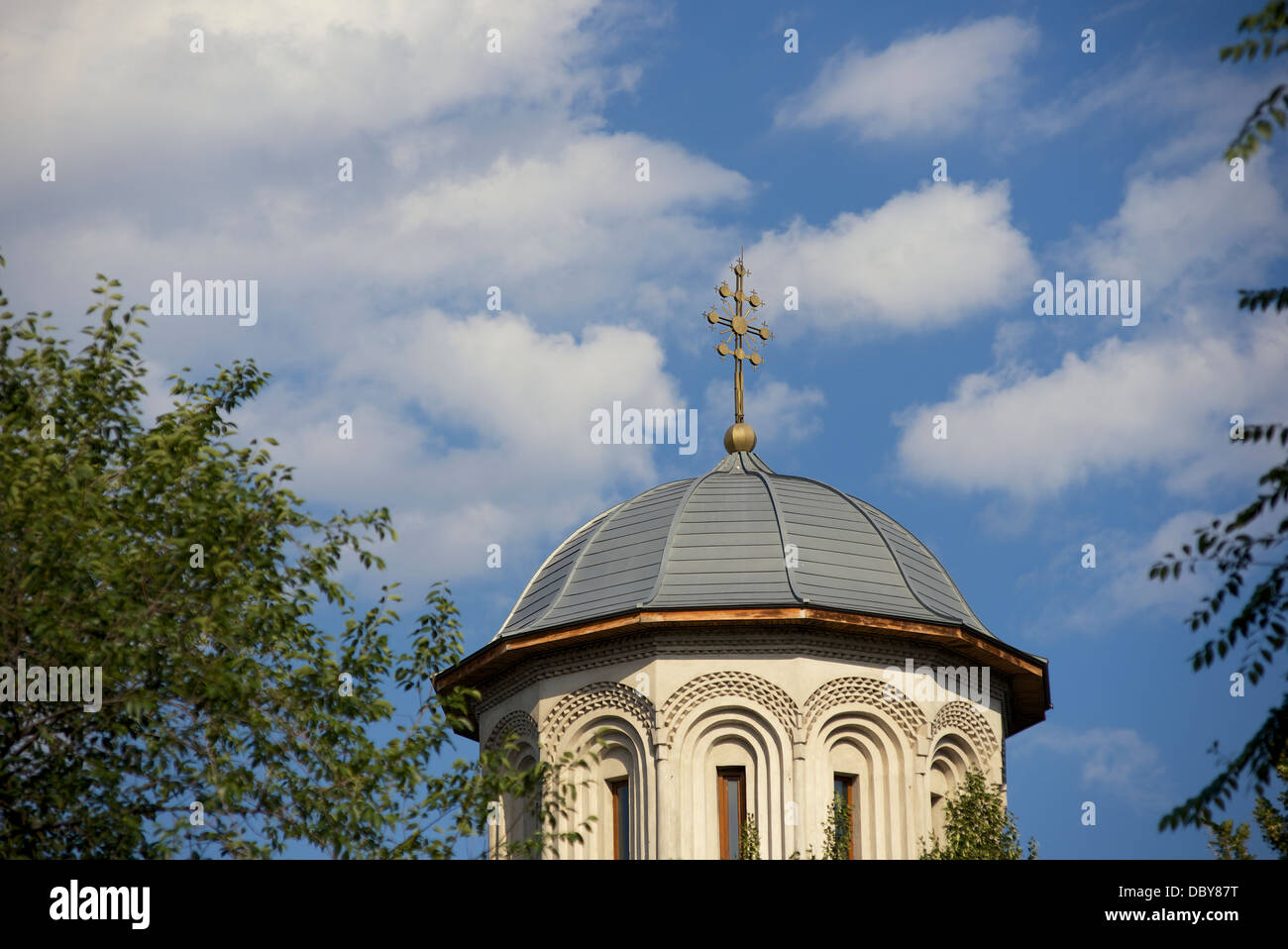 Round church spire with crucifix on top in Bucharest Stock Photo - Alamy