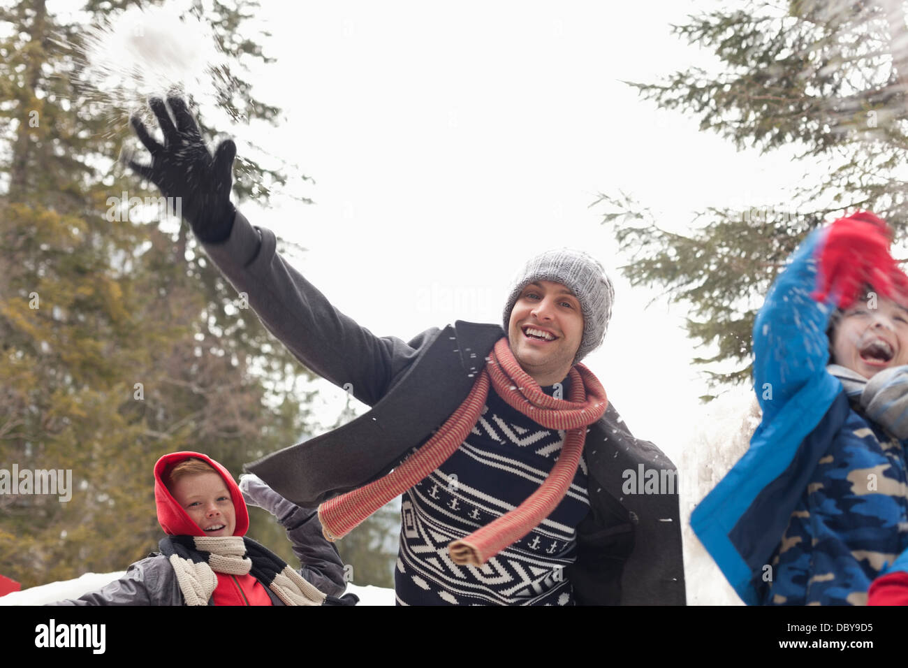 Playful father and sons throwing snow Stock Photo - Alamy