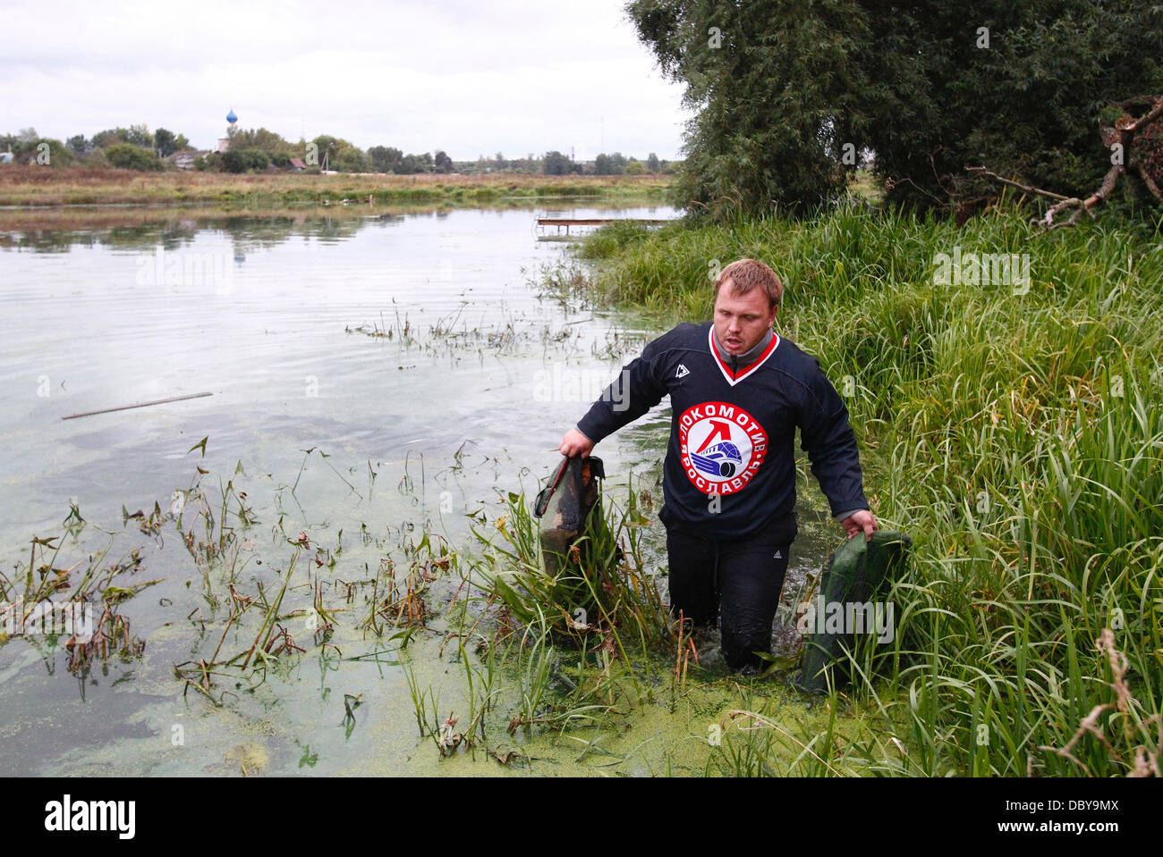 A man takes plane debris out from the water where the plane crashed ...