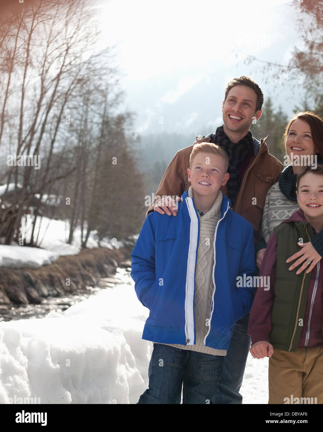 Happy family standing in snow Stock Photo - Alamy