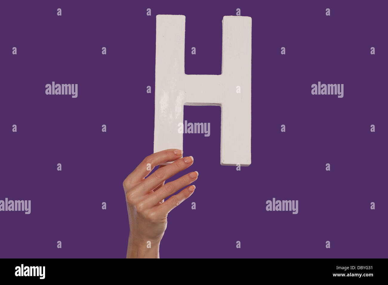 Female hand holding up the letter H from the bottom Stock Photo - Alamy