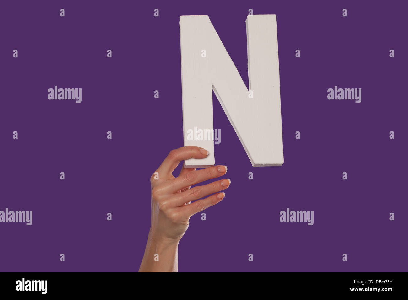 Female hand holding up the letter N from the bottom Stock Photo - Alamy