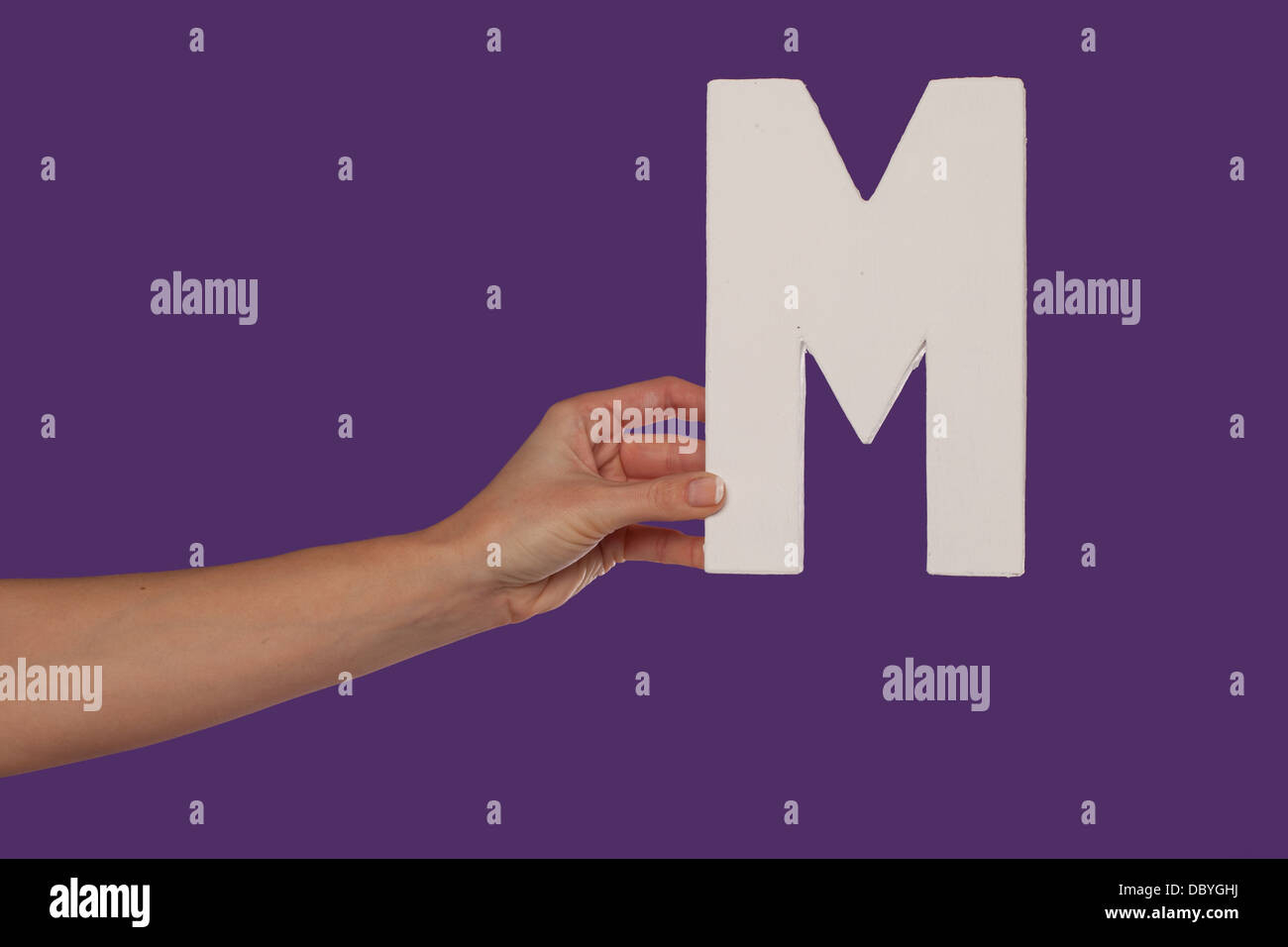 Female hand holding up the letter M from the left Stock Photo - Alamy