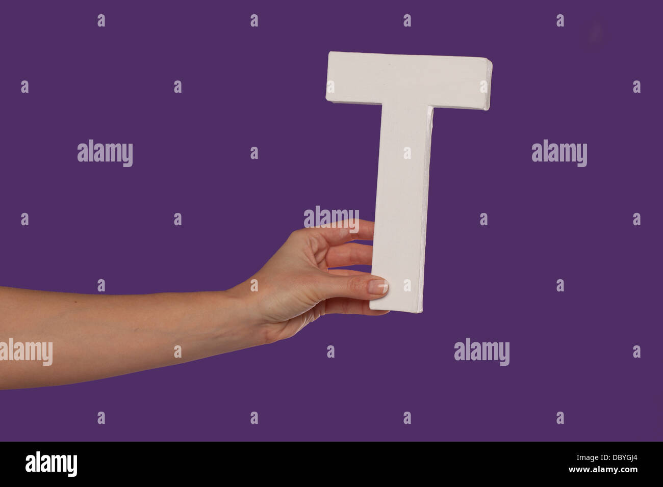 Female hand holding up the letter T from the left Stock Photo - Alamy