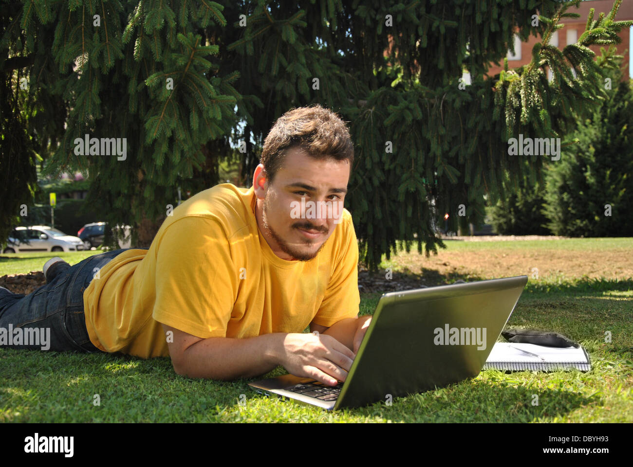 Happy student sitting on grass hi-res stock photography and images - Alamy