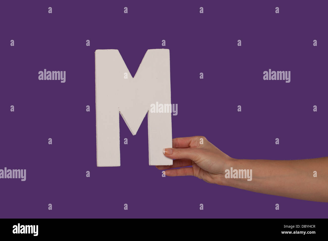 Female hand holding up the letter M from the right Stock Photo - Alamy