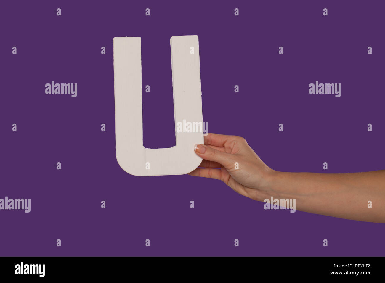Female hand holding up the letter U from the right Stock Photo - Alamy