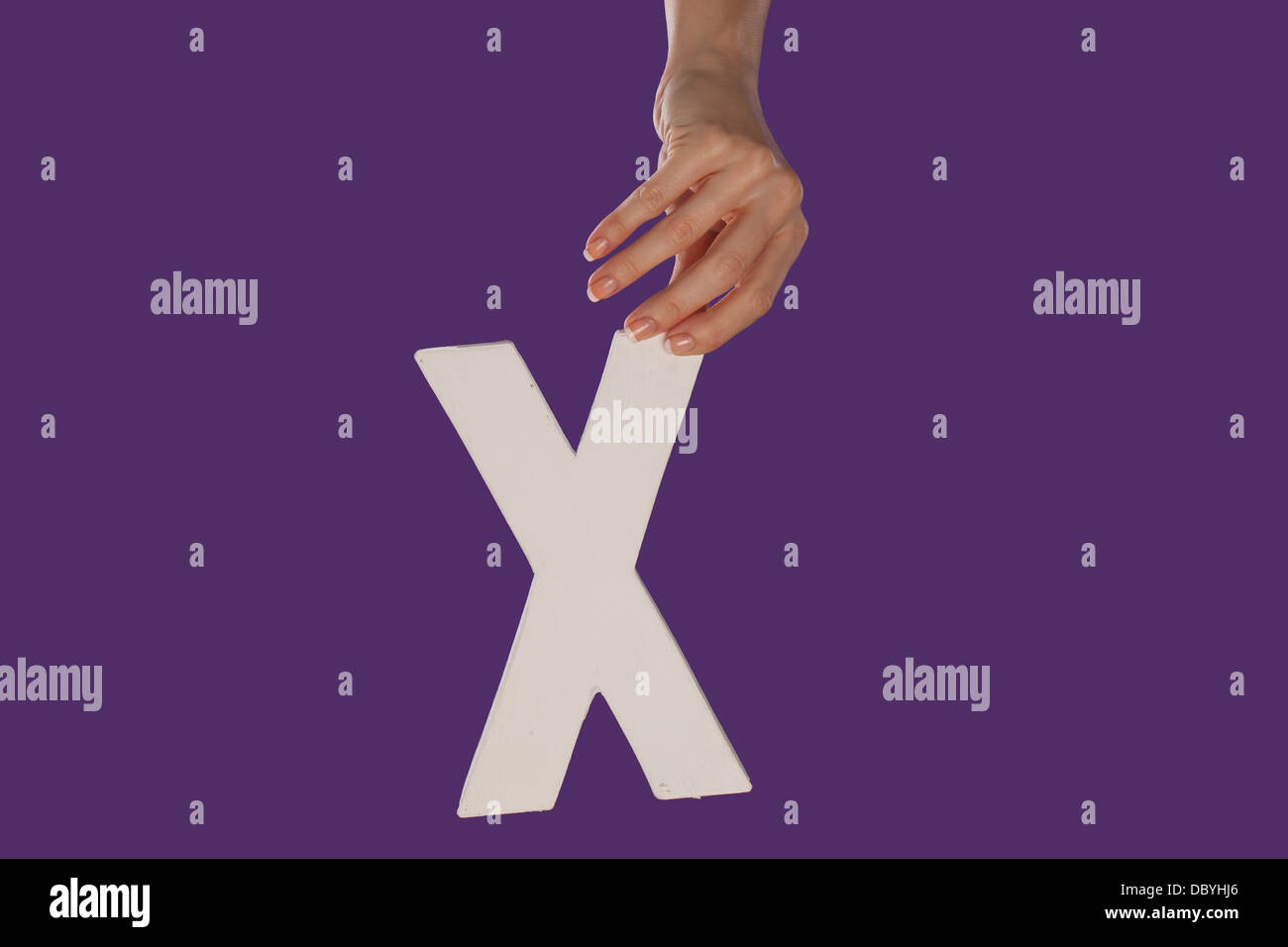 Female hand holding up the letter X from top Stock Photo - Alamy