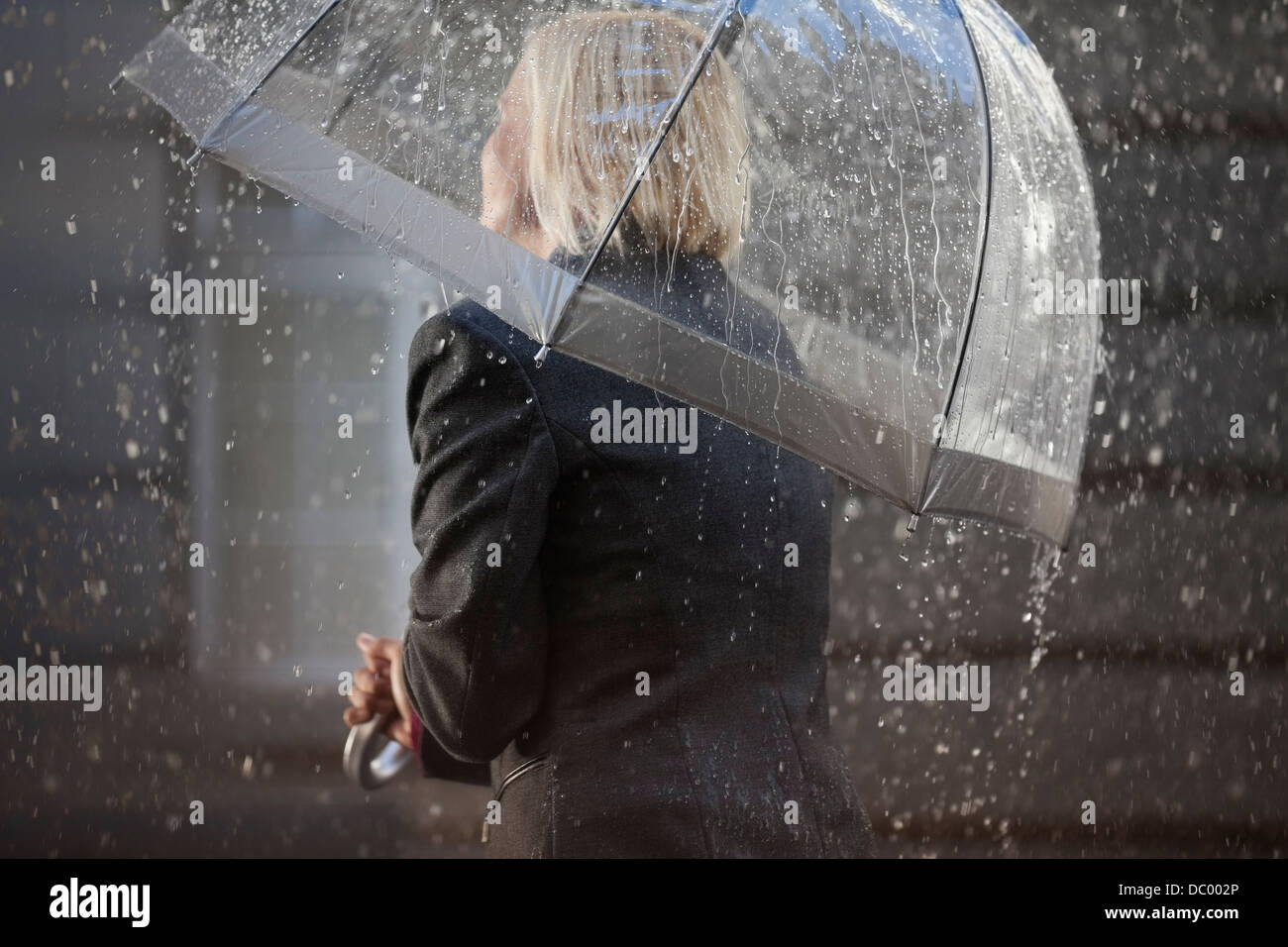 Adult woman walking under rain hi-res stock photography and images - Alamy