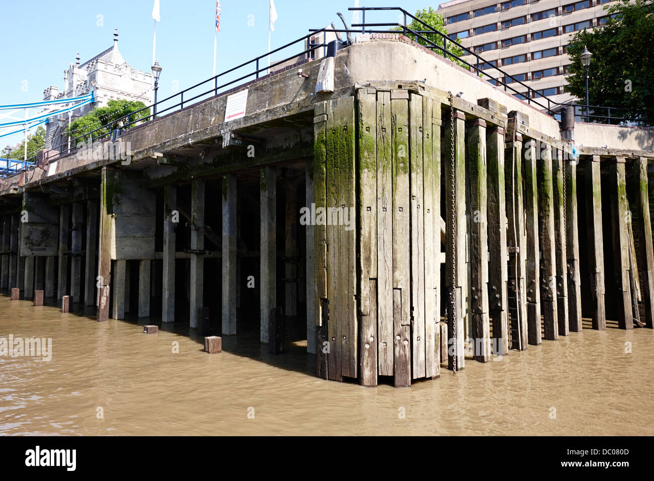 concrete piles and wooden stanchions on thames riverbank London England ...