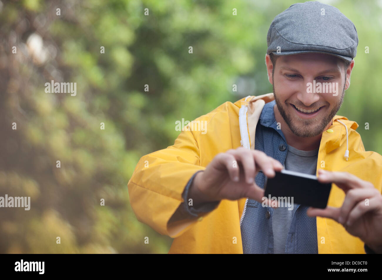 Happy man taking photograph with camera phone Stock Photo - Alamy