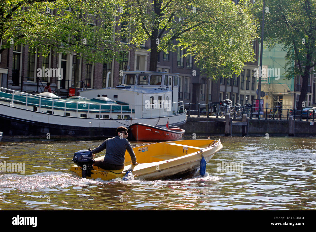 Amsterdam Netherlands Holland Europe man in small boat with outboard ...
