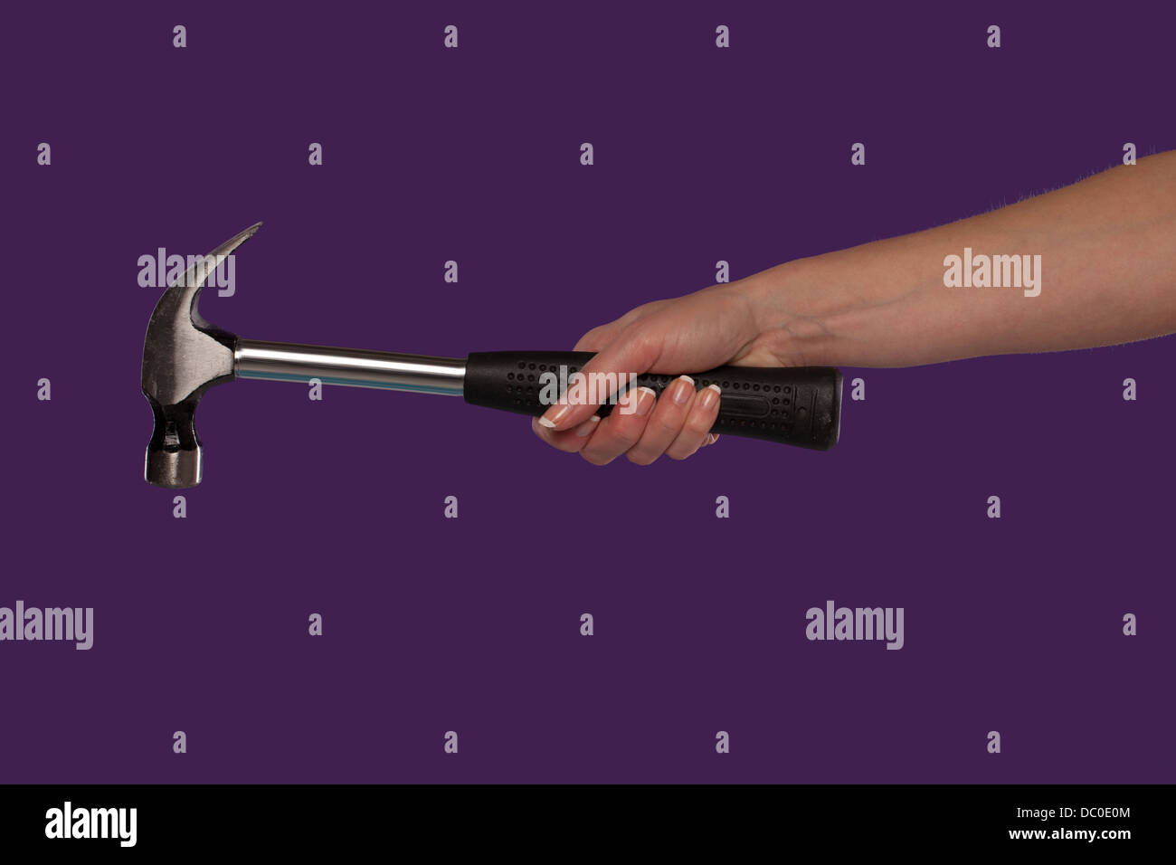 Female hand holding a claw hammer Stock Photo - Alamy
