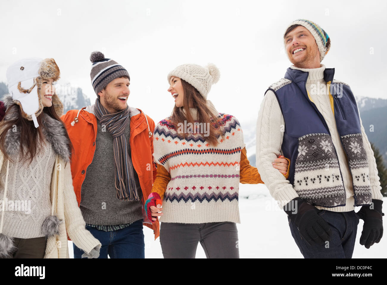 Happy friends walking in snow Stock Photo - Alamy