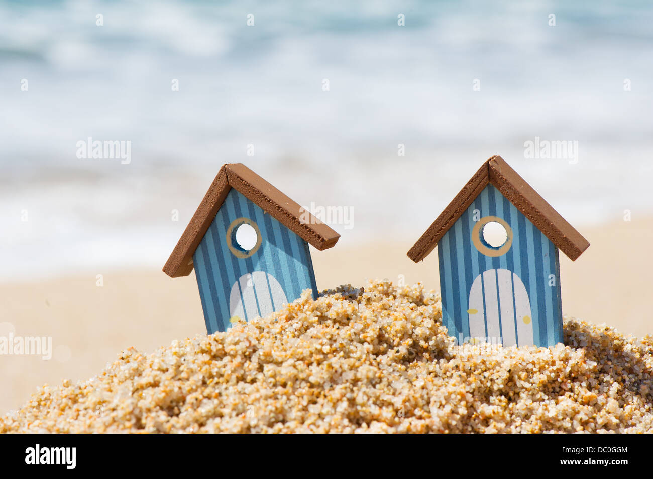 Miniature beach huts with the water line Stock Photo - Alamy