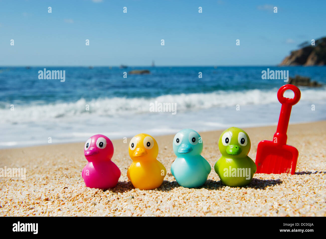Colorful toy ducks in the sand at the beach Stock Photo - Alamy