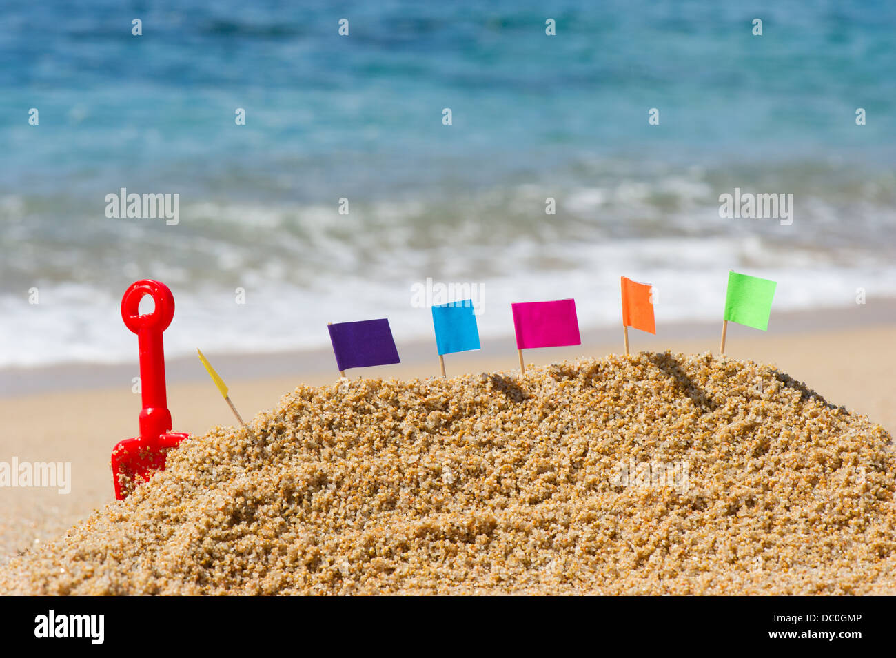 Sand castle with colorful flags at the beach Stock Photo - Alamy