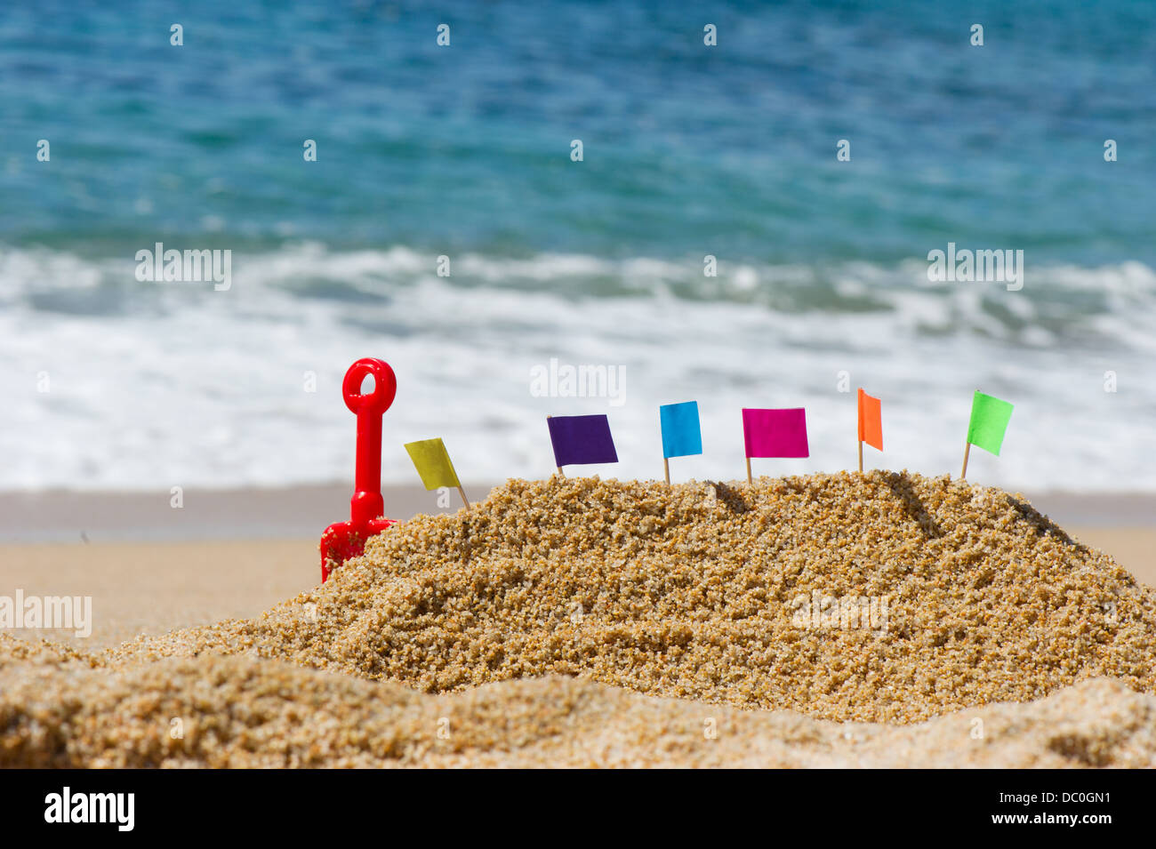 Sand castle with colorful flags at the beach Stock Photo - Alamy