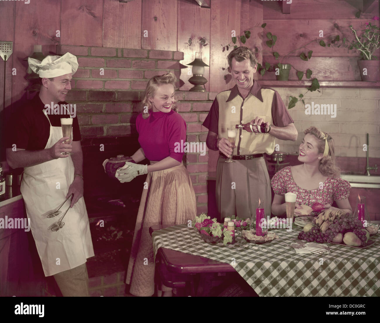 1950s 2 COUPLES COOKING PICNIC IN RUSTIC KITCHEN DRINKING BEER Stock ...