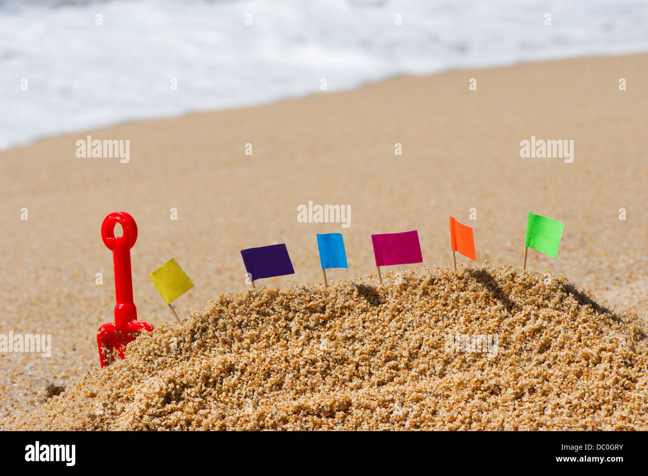 Sand castle with colorful flags at the beach Stock Photo - Alamy