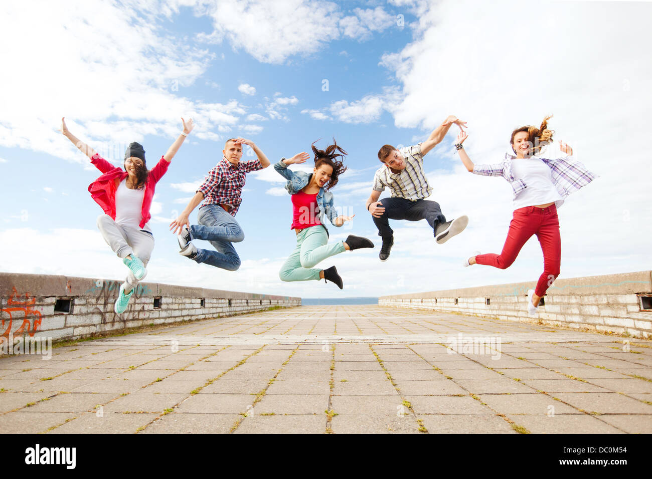 group of teenagers jumping Stock Photo - Alamy