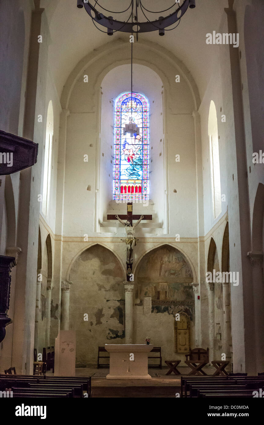 Stained glass window and cross in the tall and narrow Church of Saint ...