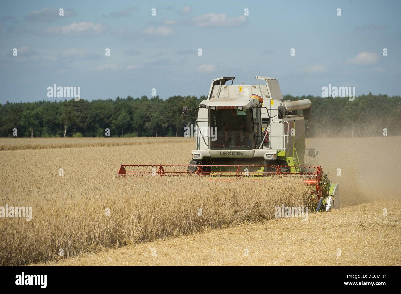 A combine harvester drives over a field of wheat near Lehrte, Germany ...