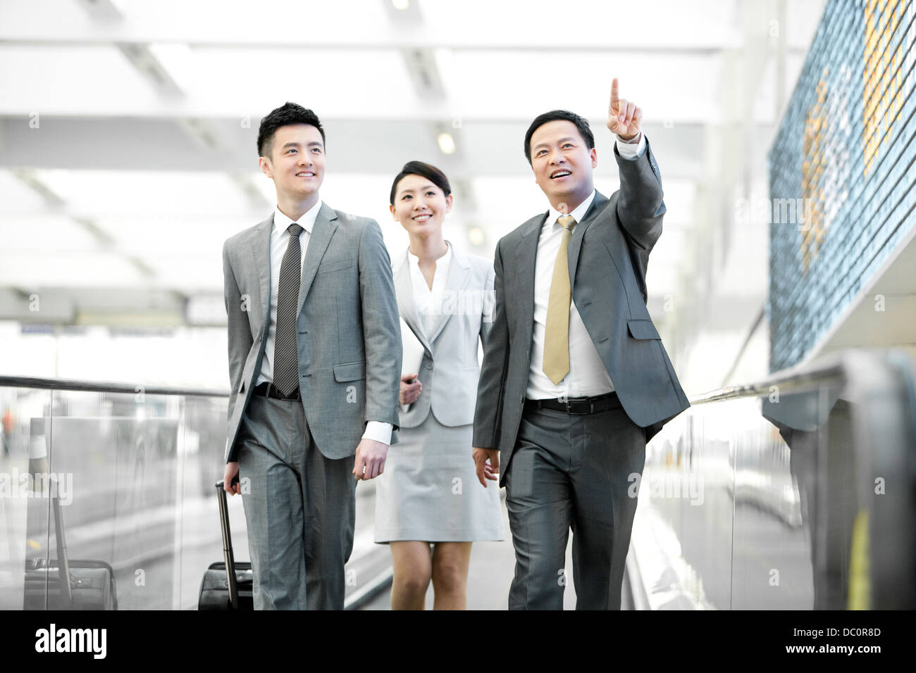 Business team walking on moving walkway Stock Photo - Alamy