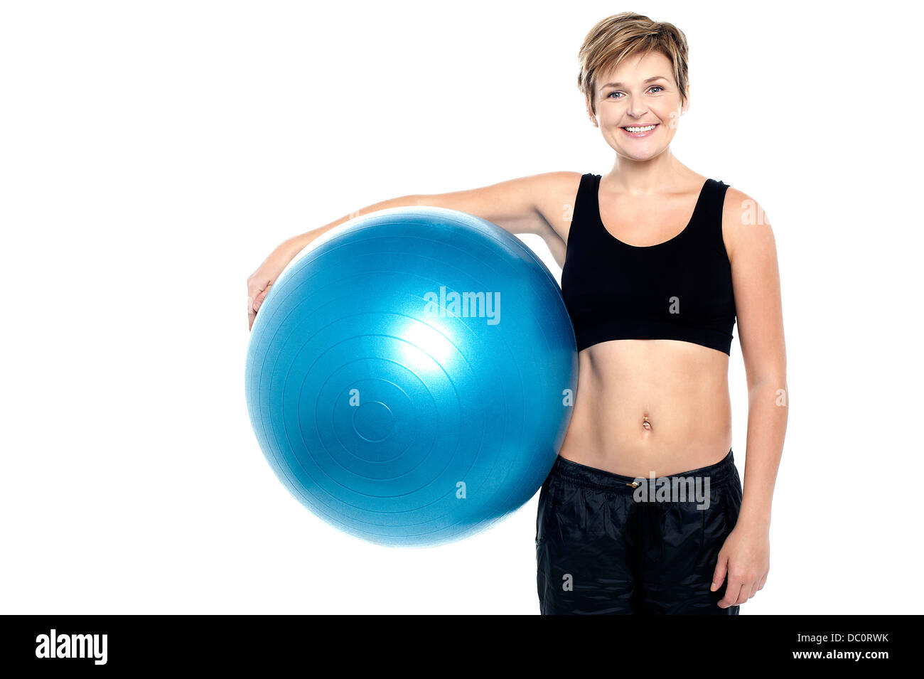 An attractive fit lady holding blue pilates ball Stock Photo - Alamy