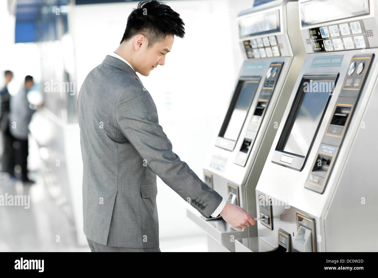 Young businessman using automatic ticket machine at subway station ...