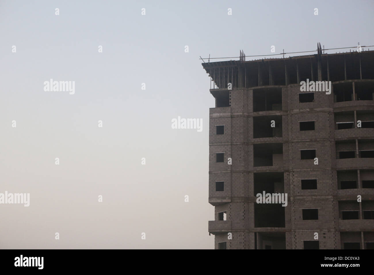 The empty shell of a building in the middle of construction at dusk ...