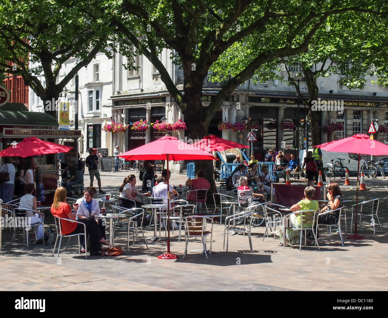 People drinking coffee outdoors at an independent coffee kiosk in a ...