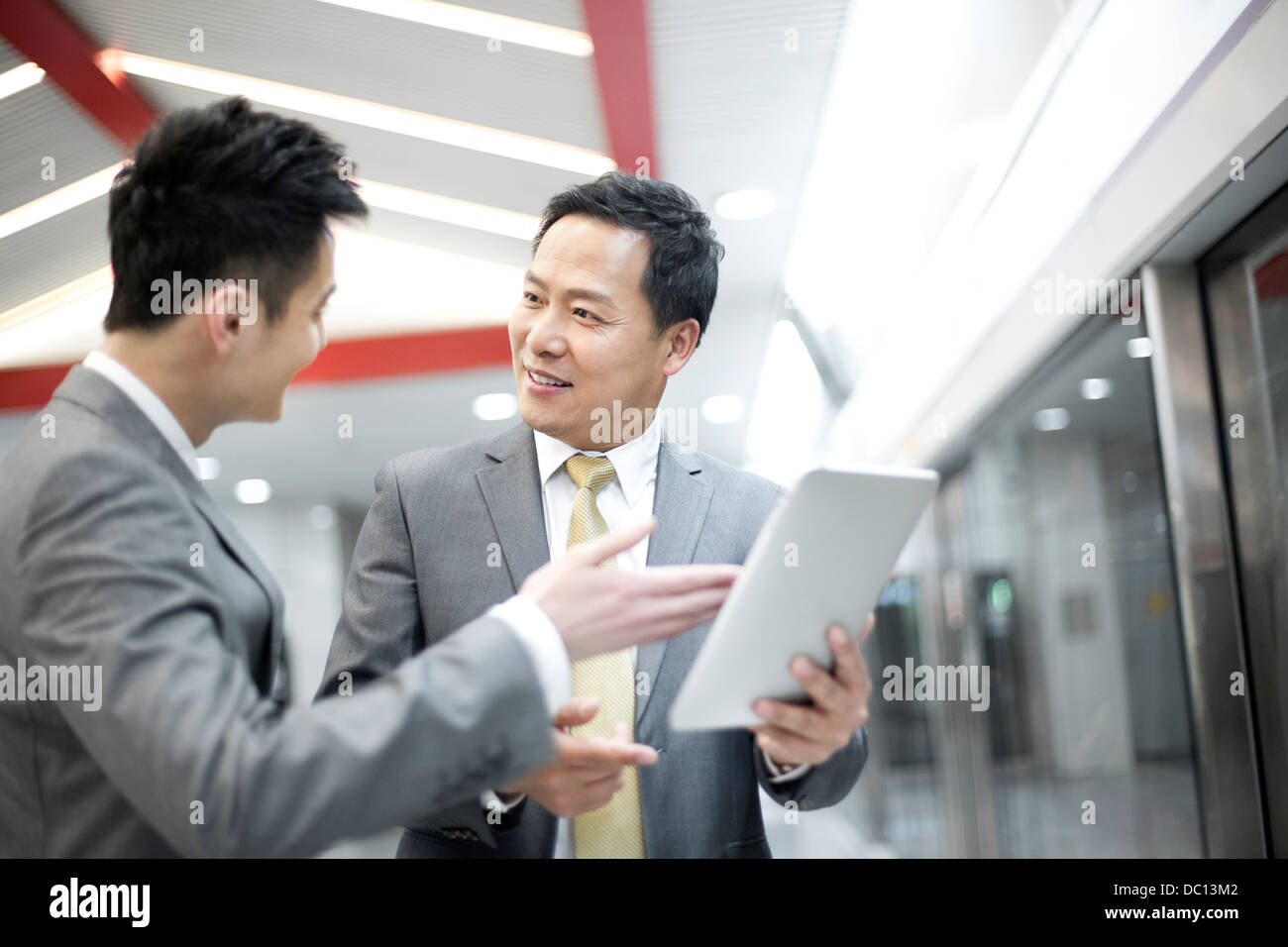 Business partners with digital tablet on subway platform Stock Photo ...