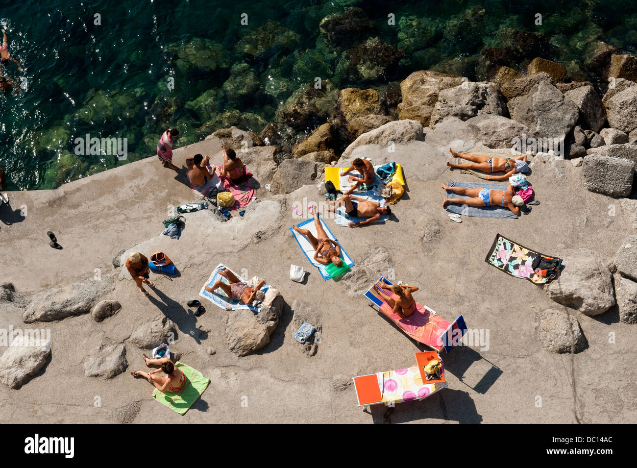 Sunbathers on a rocky outcrop, on the Amalfi Coast, Italy Stock Photo ...