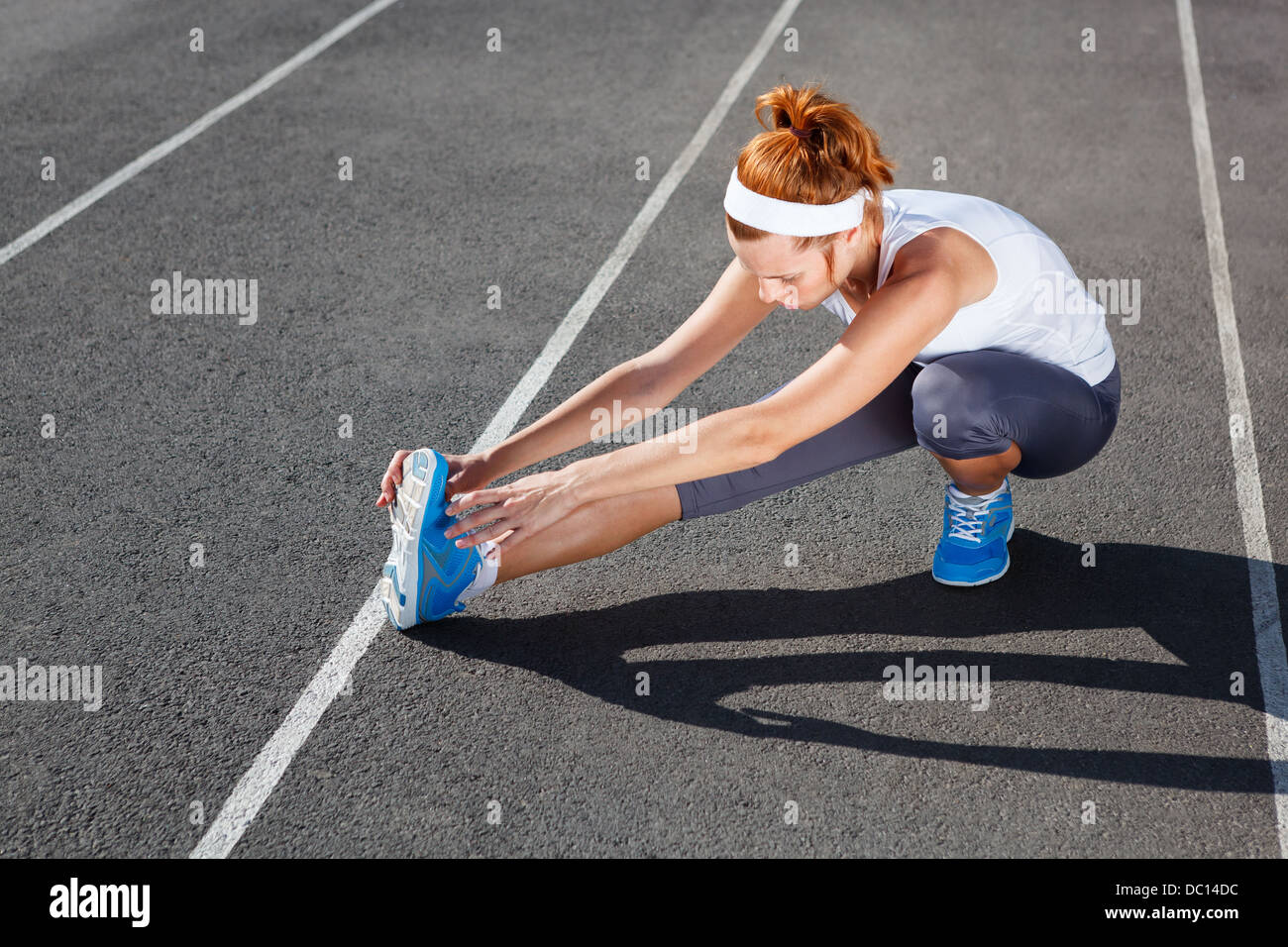 Female runner stretching before workout - outdoor shot Stock Photo - Alamy